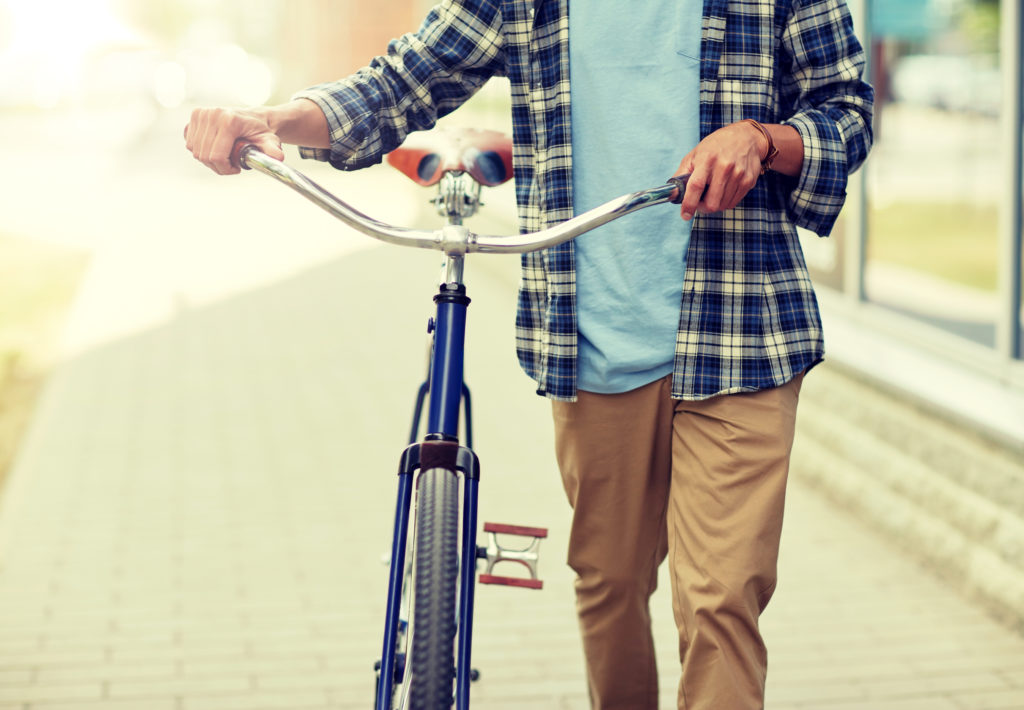 close up of man with bicycle walking along city - VBE